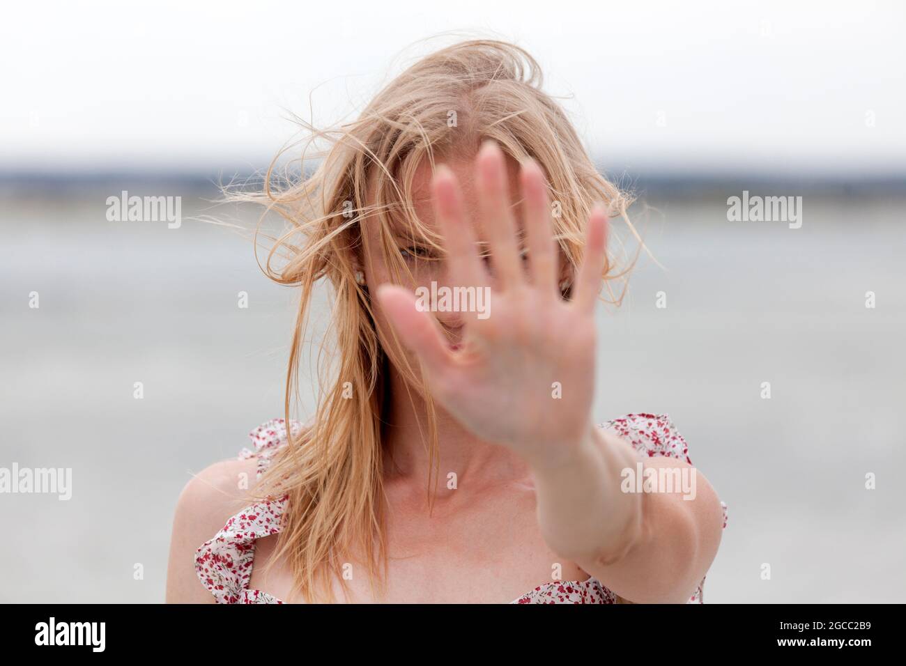 Pretty woman makes hand stop with five fingers Stock Photo - Alamy