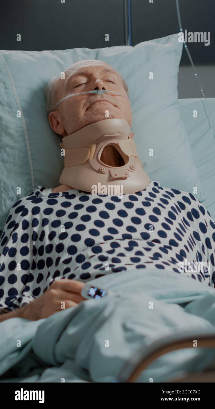 Patient with cervical collar for neck laying in hospital ward bed with ...