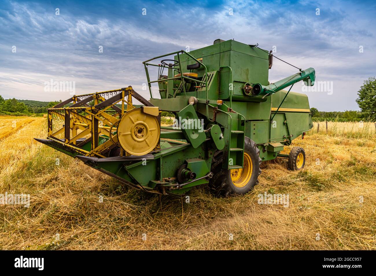 Old combine harvester on a wheat field with blue sky Stock Photo - Alamy