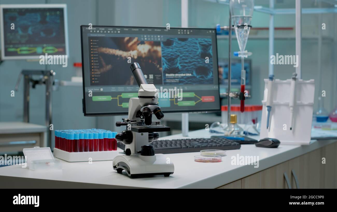Microscope on laboratory desk with medical research equipment at ...
