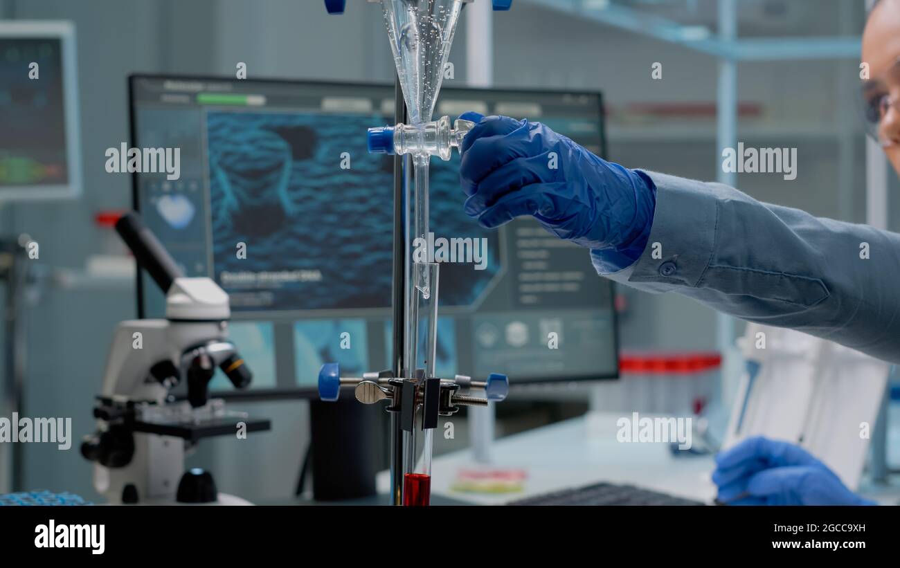 Science specialist using chemical test tube in laboratory on desk with ...