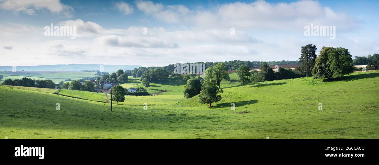 countryside landscape with green meadows and village in french ardennes ...