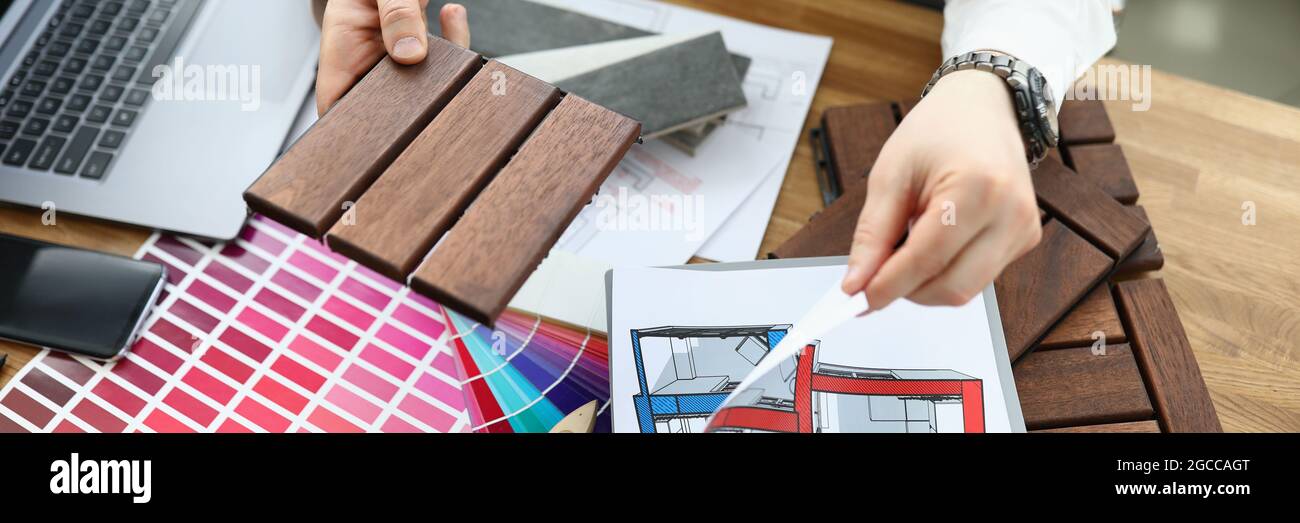 Designer with samples of materials at work table Stock Photo - Alamy