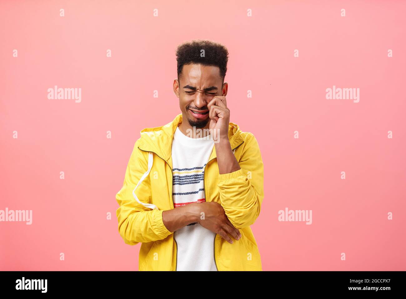 Studio shot of silly sad african american timid guy in yellow trendy ...