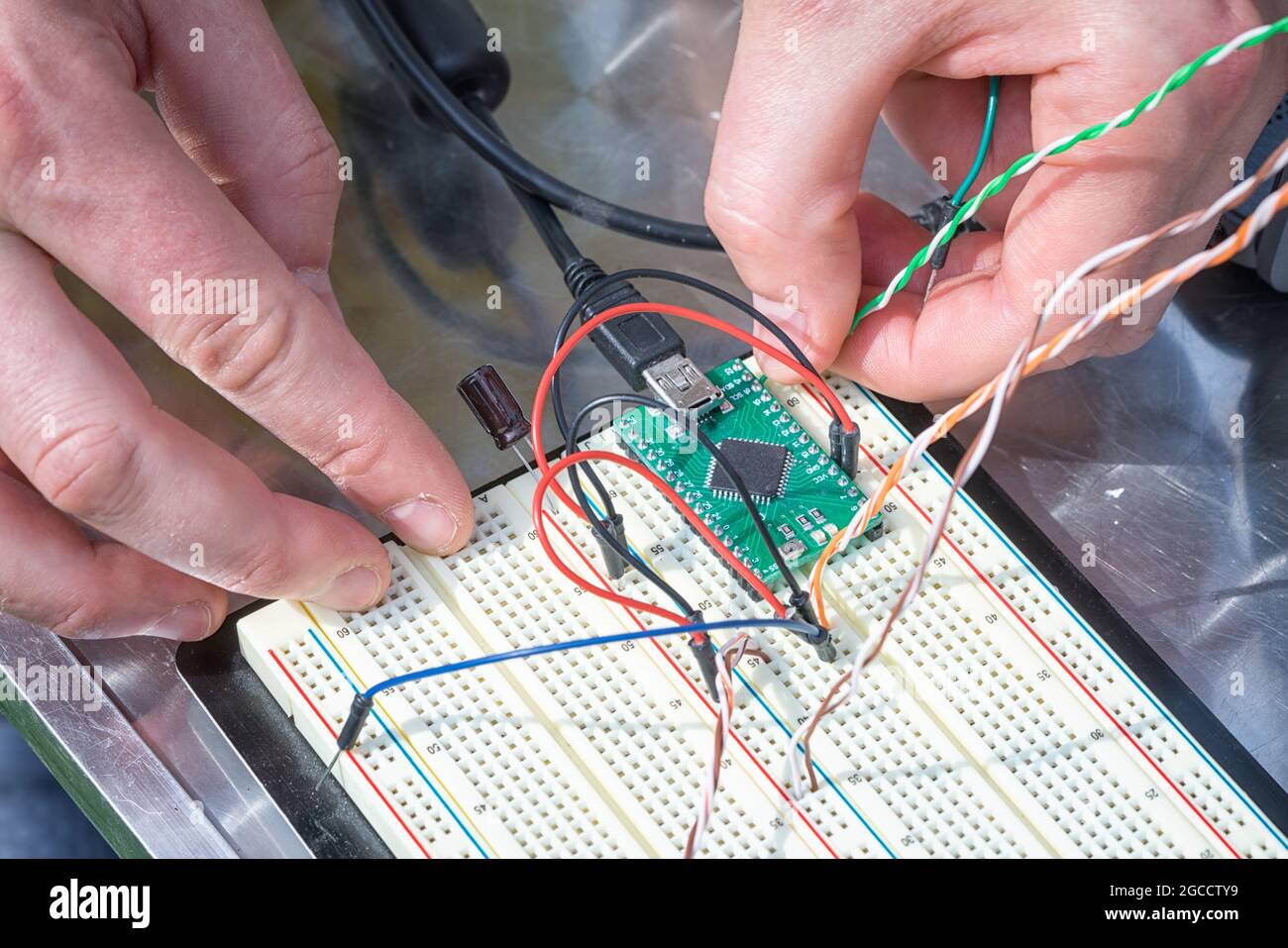 Hands connect electronic contacts Stock Photo - Alamy
