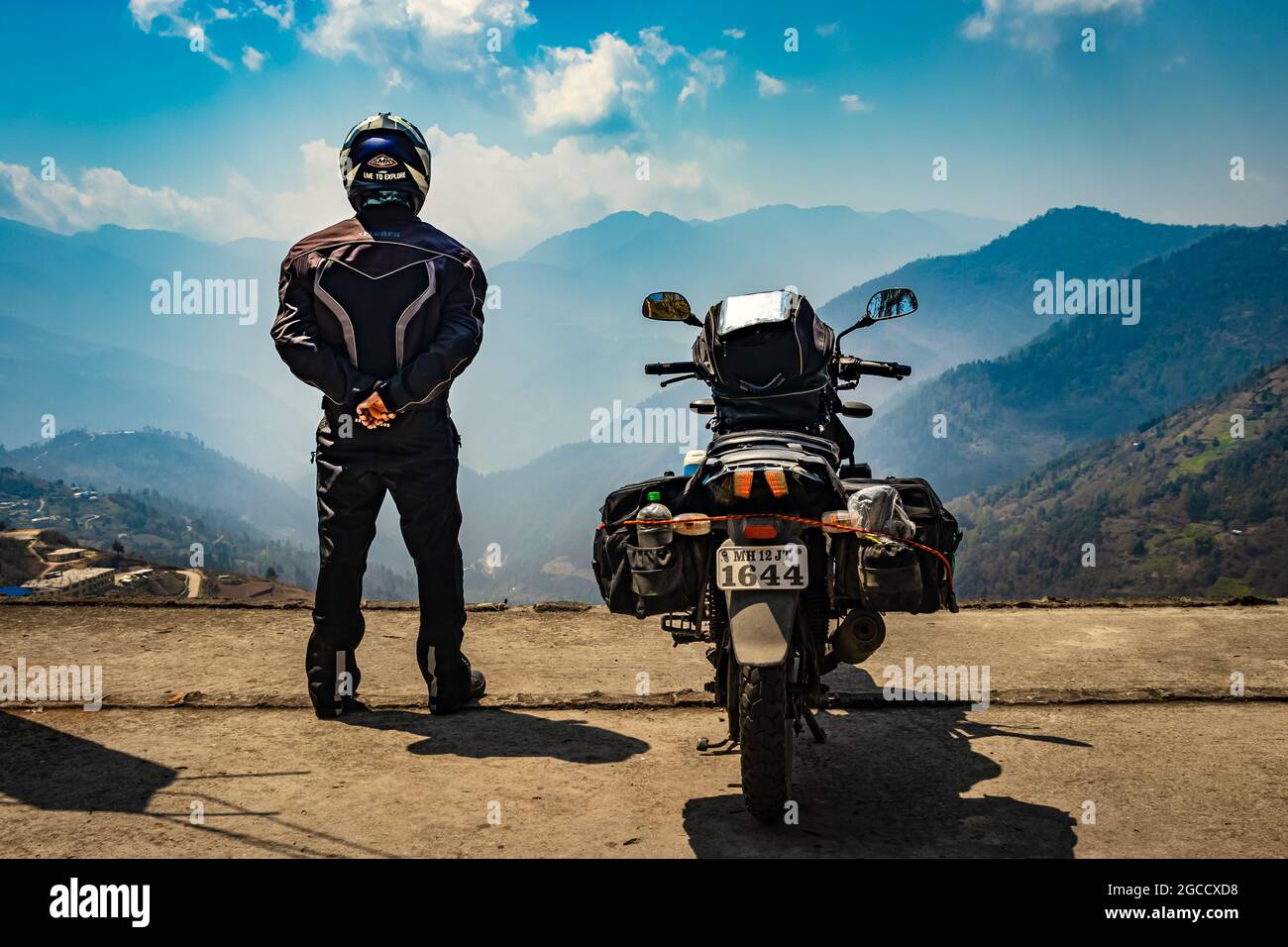 man motorcyclist with his loaded motorcycle and pristine natural view ...