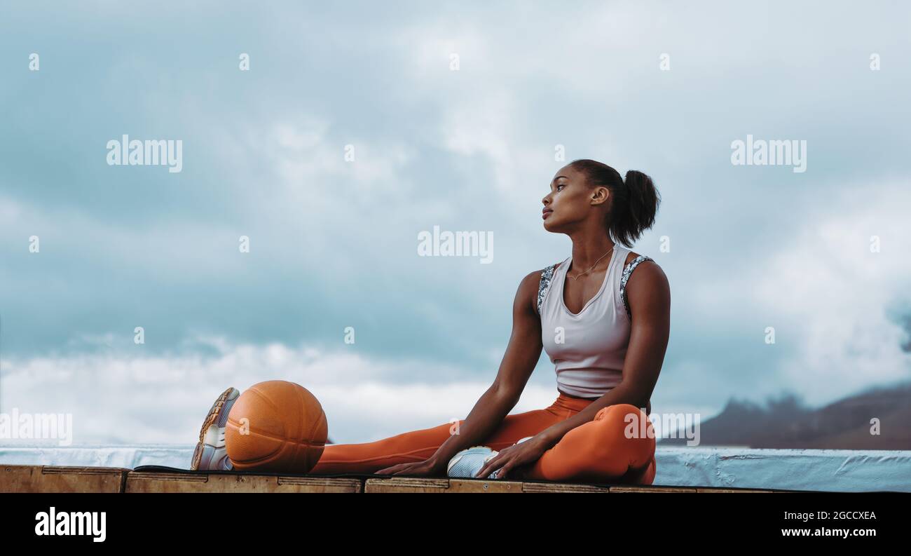 fitness woman relaxing after workout on rooftop. Sporty female with ...