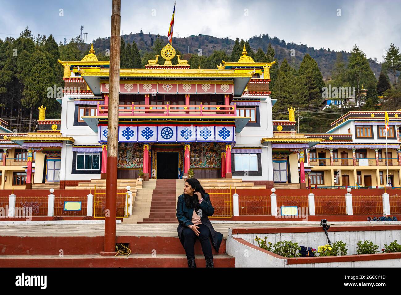 young girl sitting in front of ancient buddhist colorful monastery at ...