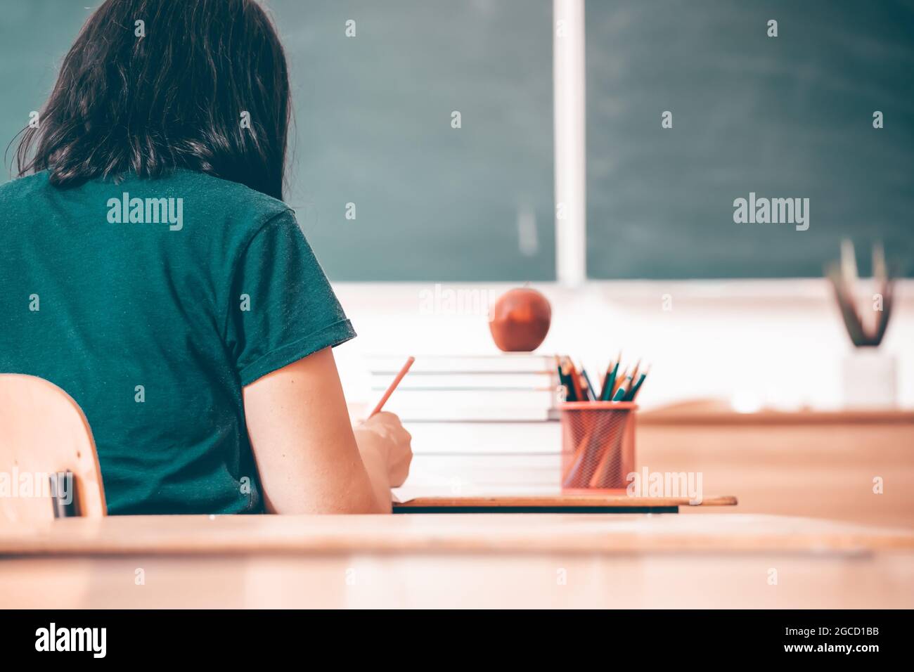 High school or university student holding pencil writing on paper ...