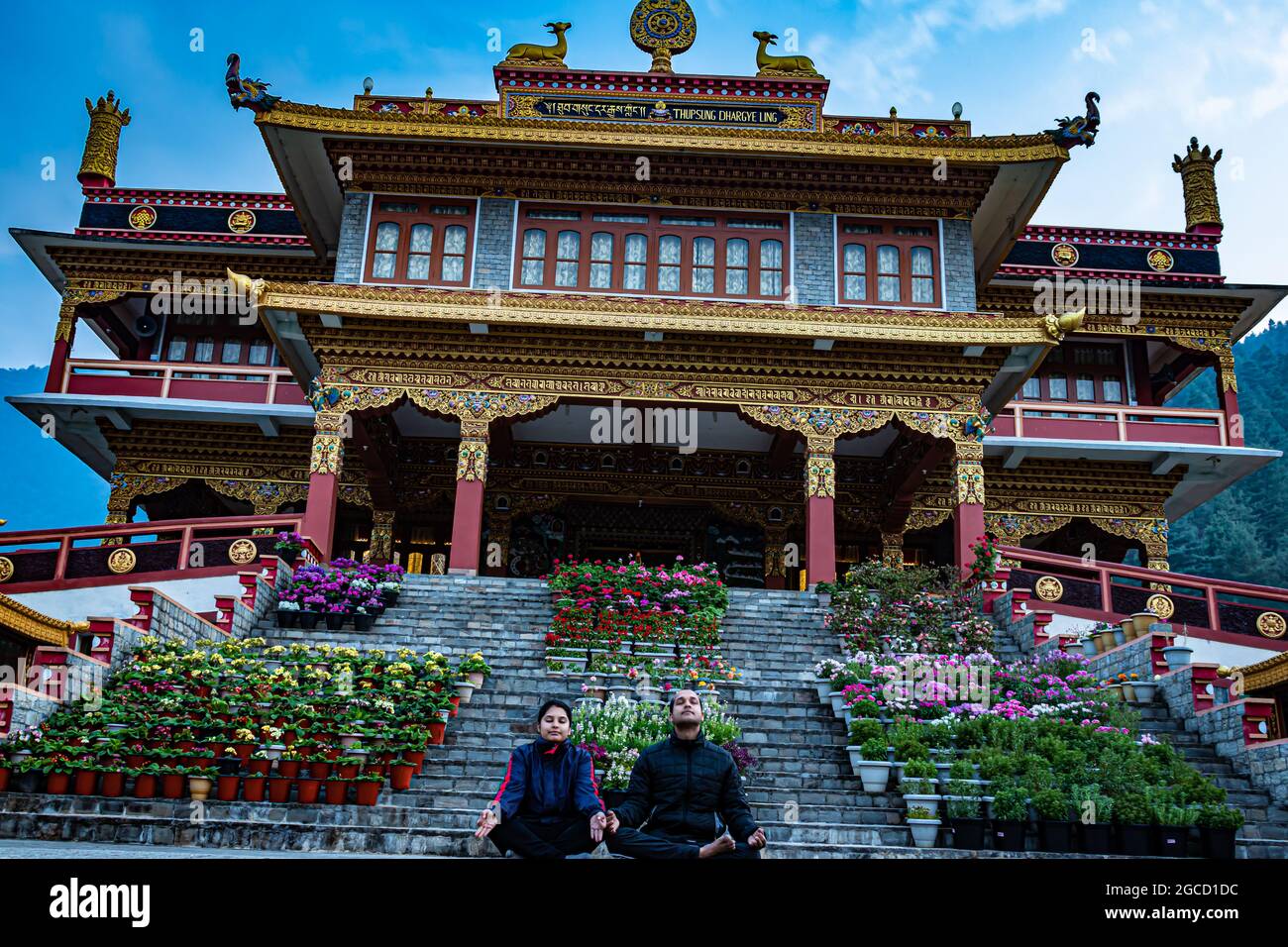 young couple meditating near buddhist monastery at morning from low ...