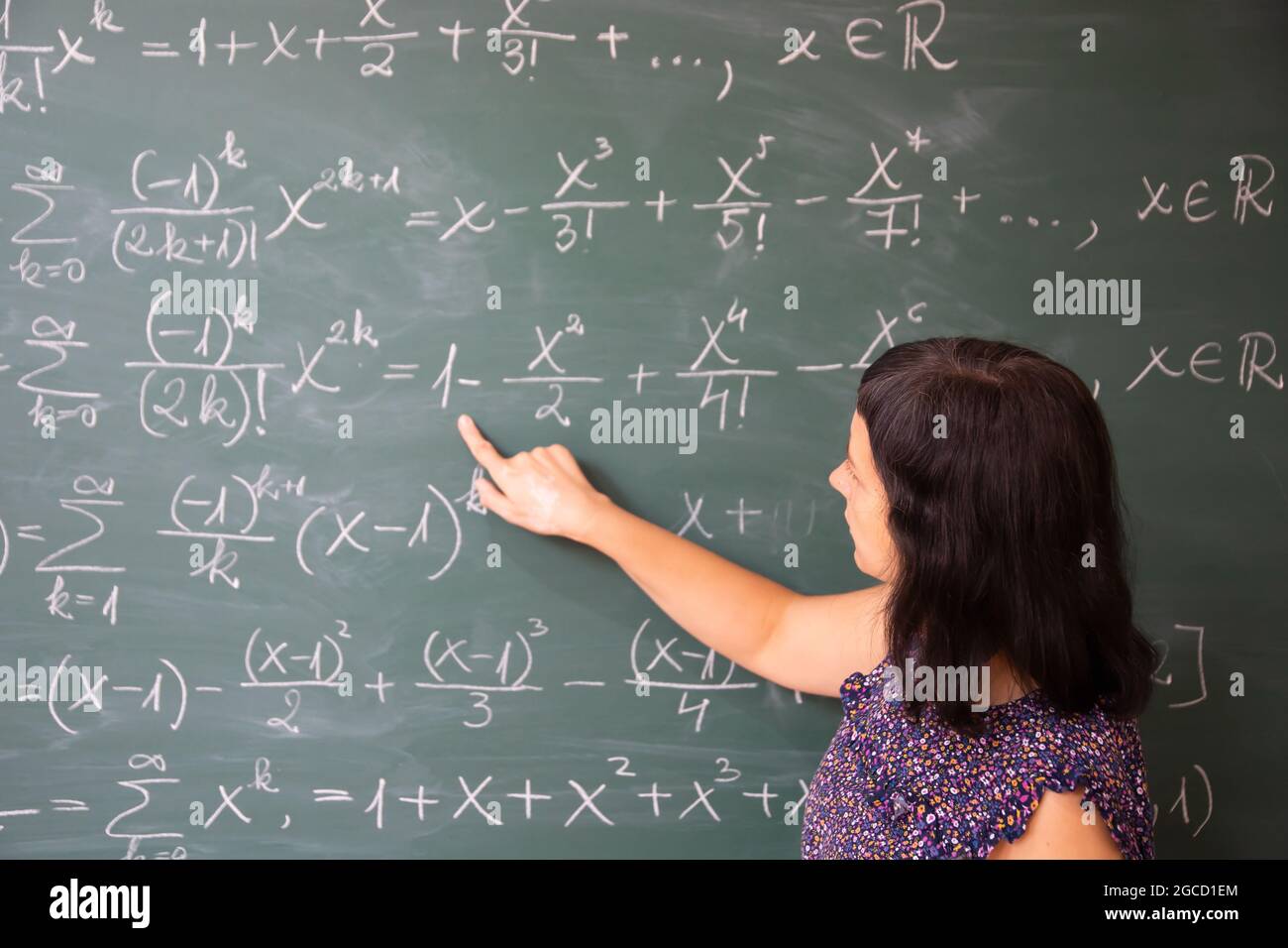 Teacher or student explaning on blackboard during math lesson in school ...