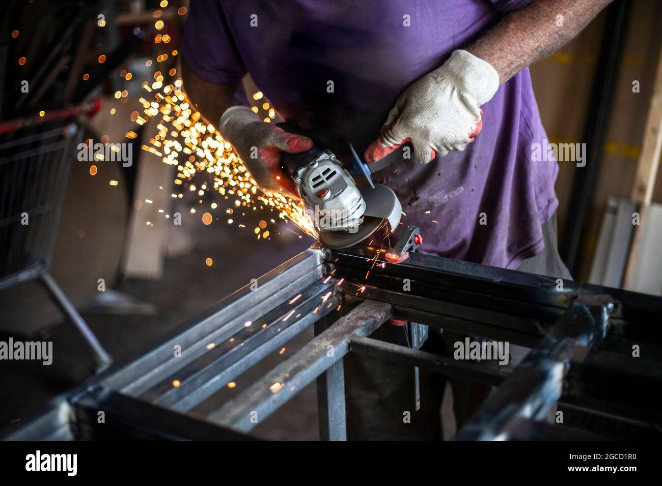 Metal processing in the workshop. Grinding metal. The worker makes the ...