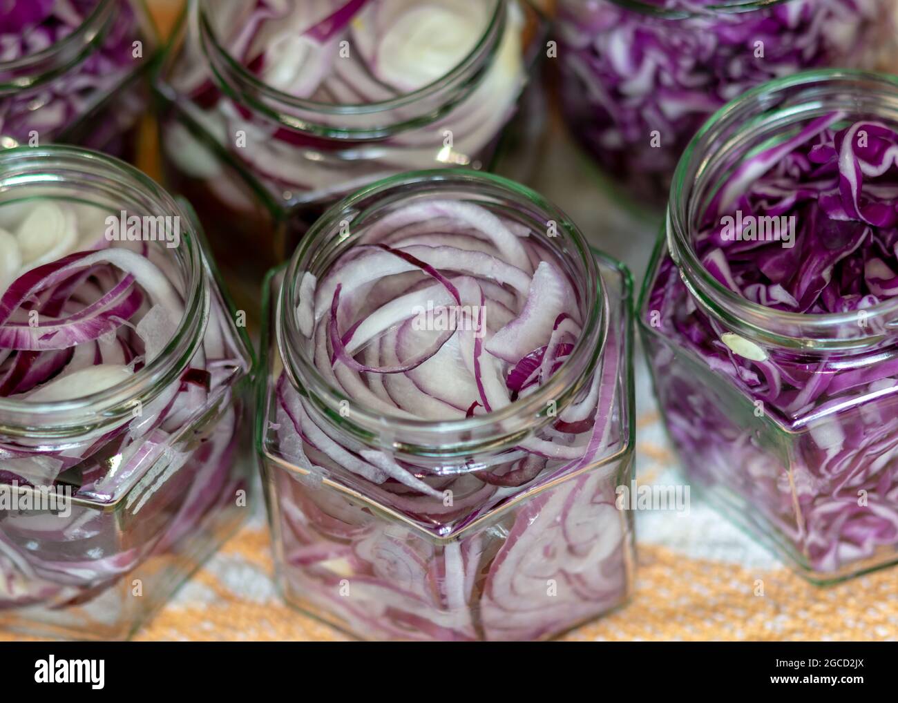 glass jars with sliced red cabbage and onions, vegetables prepared for ...