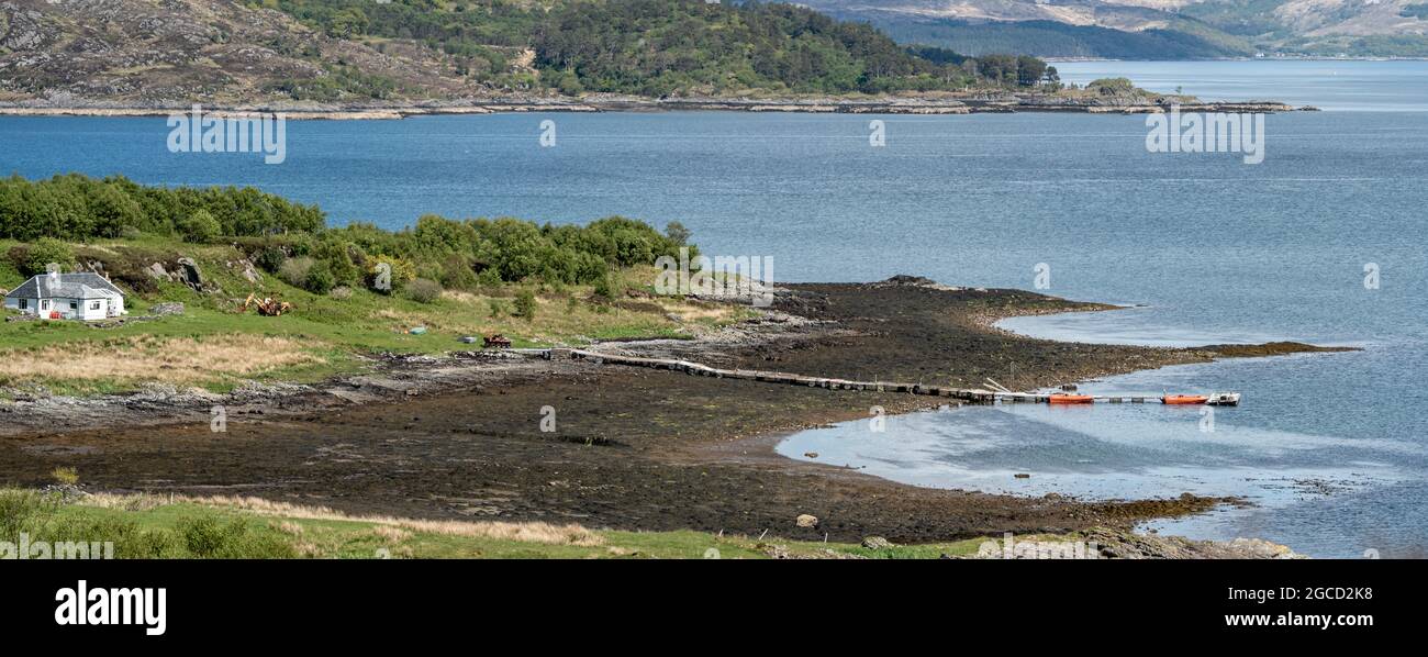Panoramic view of Isle of Carna coastline with jetty and boats in ...
