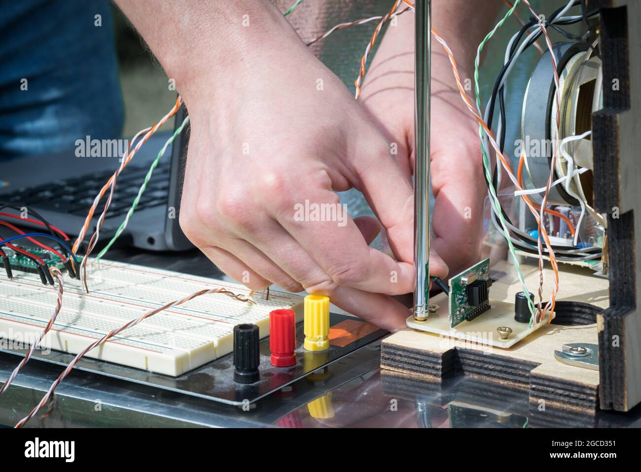 Hands connect electronic contacts of homemade radio. Hobby of making ...