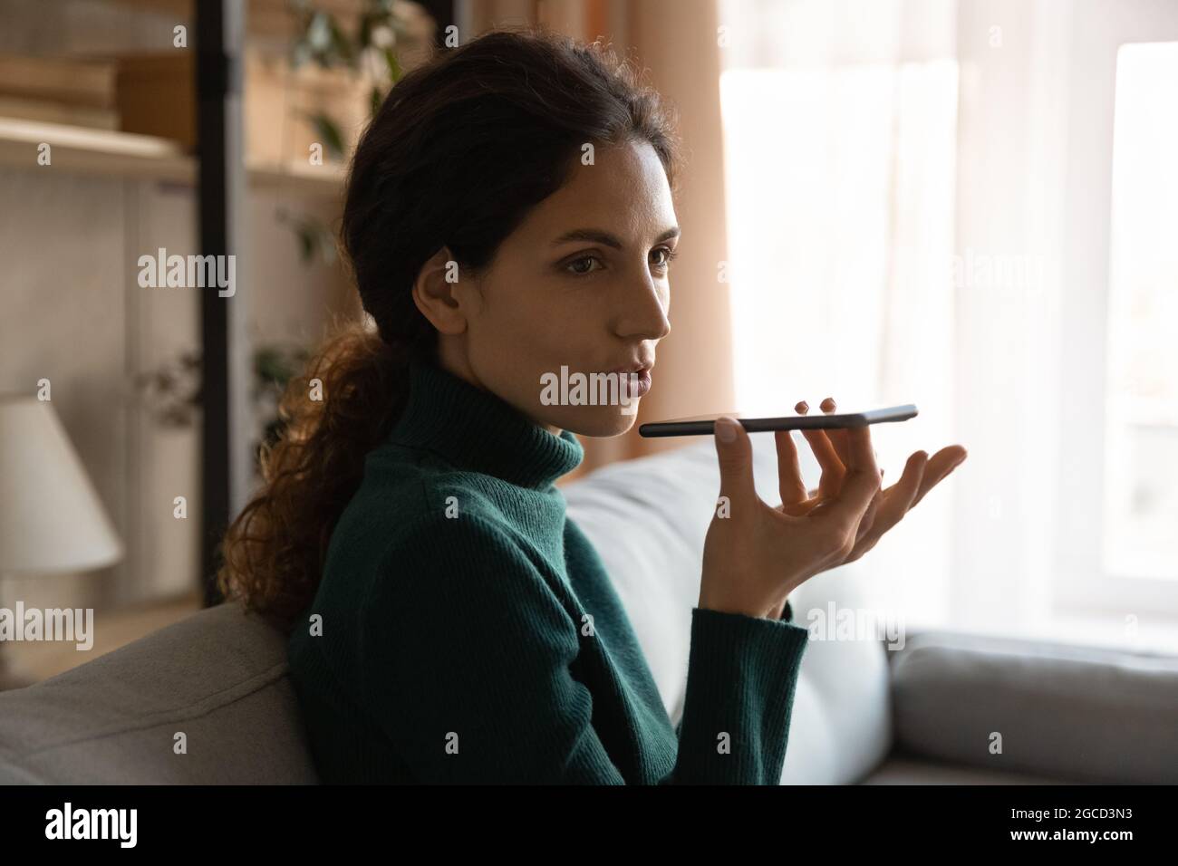 Close up confident woman recording audio voice message on smartphone ...