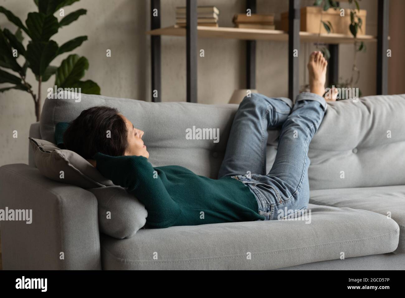 Close up peaceful barefoot young woman resting on couch Stock Photo - Alamy