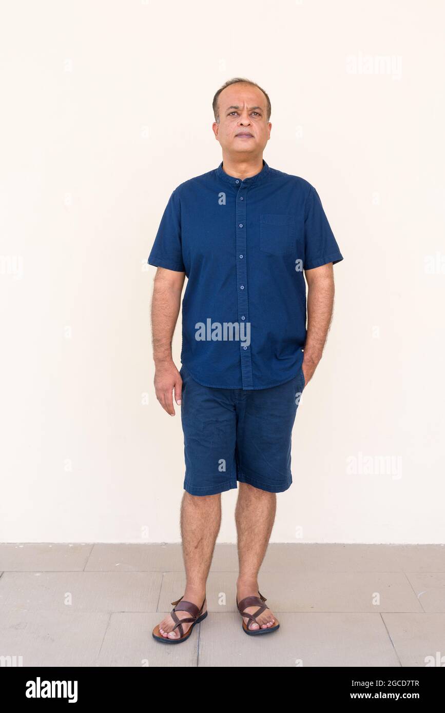 Full length portrait of Indian man standing against plain wall Stock ...