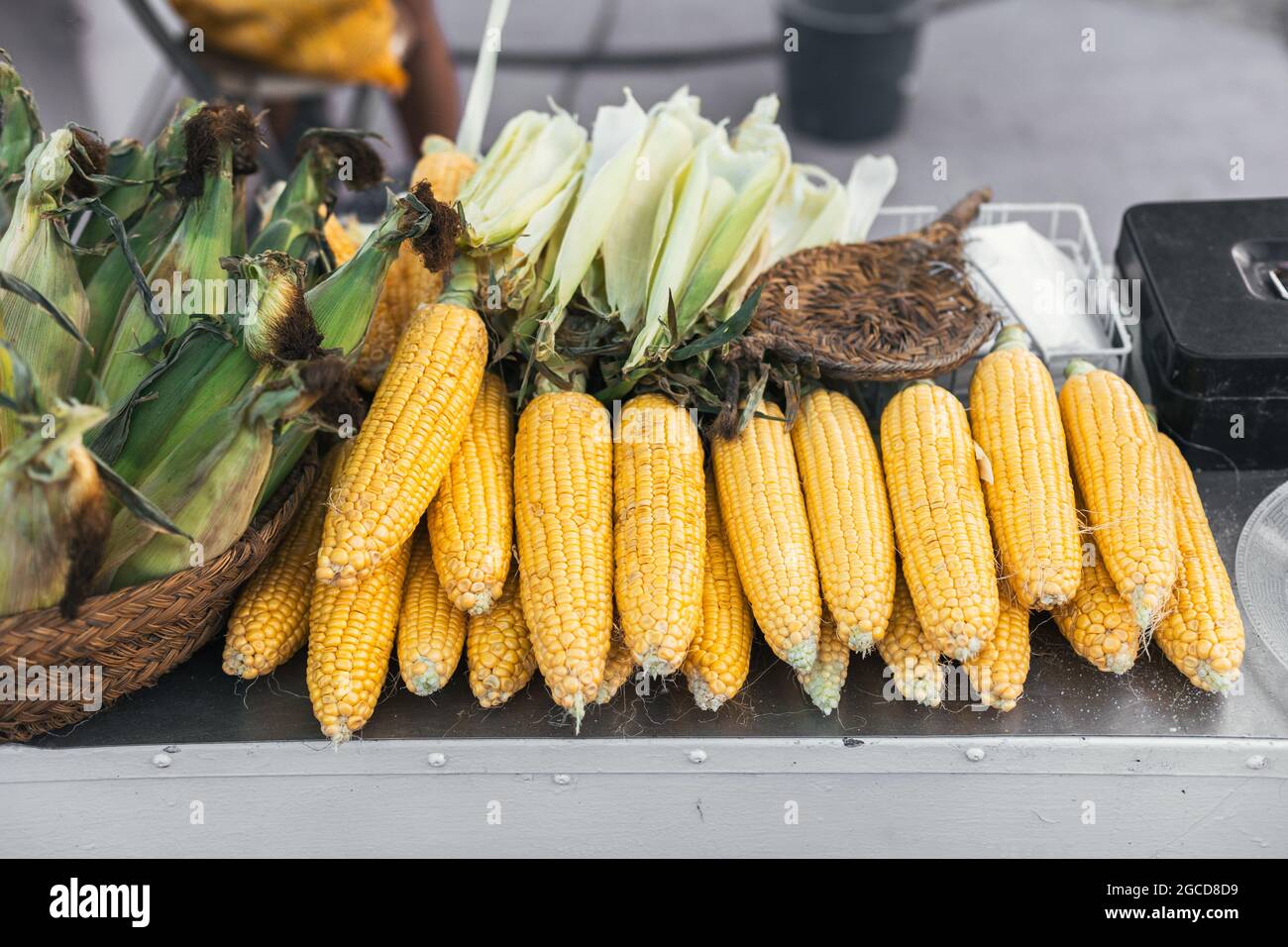 A pile of fresh raw corncobs on the table at a street food stall Stock ...