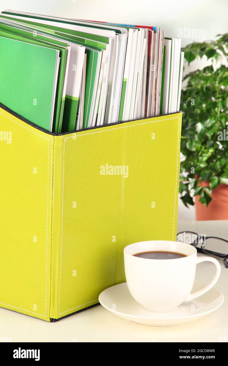 Magazines and folders in green box,on office interior background Stock ...