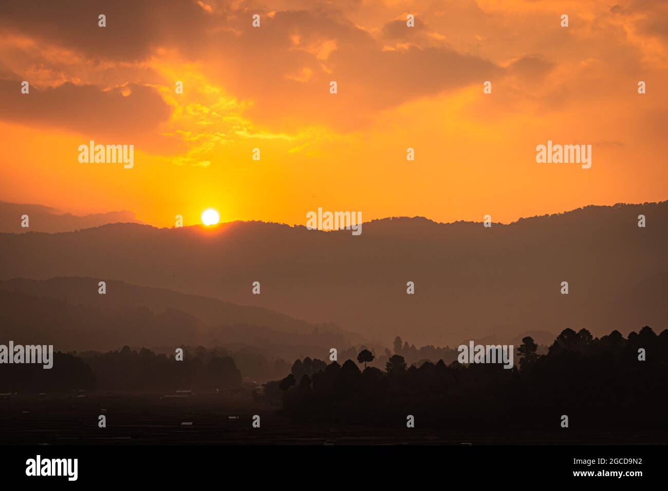 sunrise over mountains with orange dramatic sky at dawn at village ...