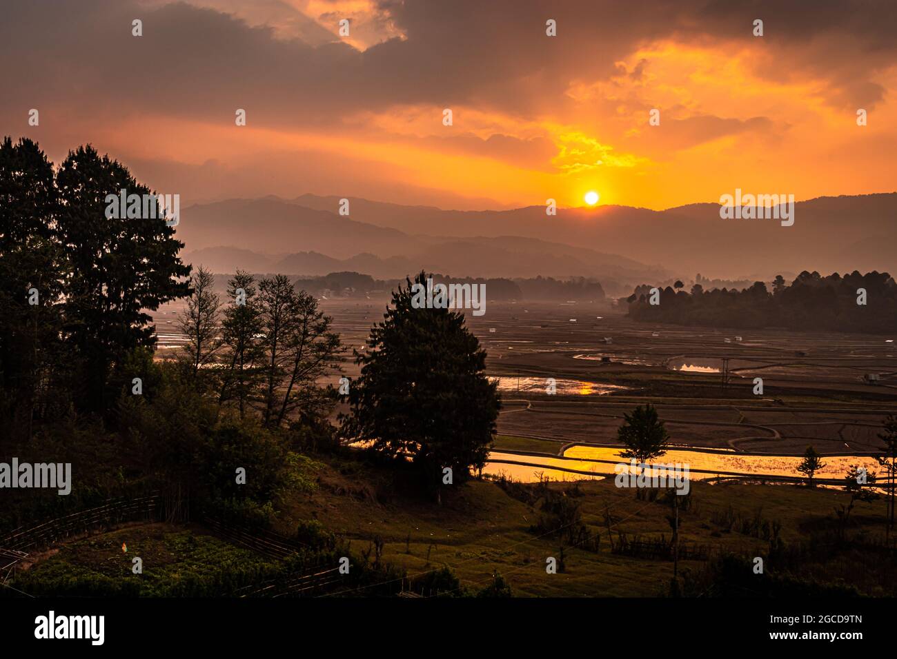 sunrise over mountains with country side farming fields and orange ...