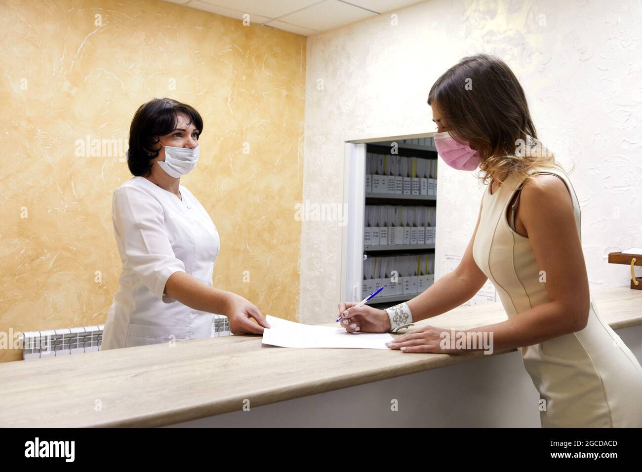 Woman signing paper reception desk hi-res stock photography and images ...