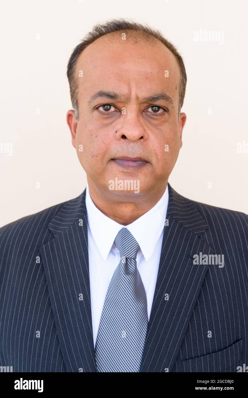 Portrait of Indian businessman against plain wall outdoors Stock Photo ...