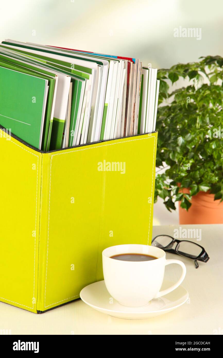 Magazines and folders in green box,on office interior background Stock ...