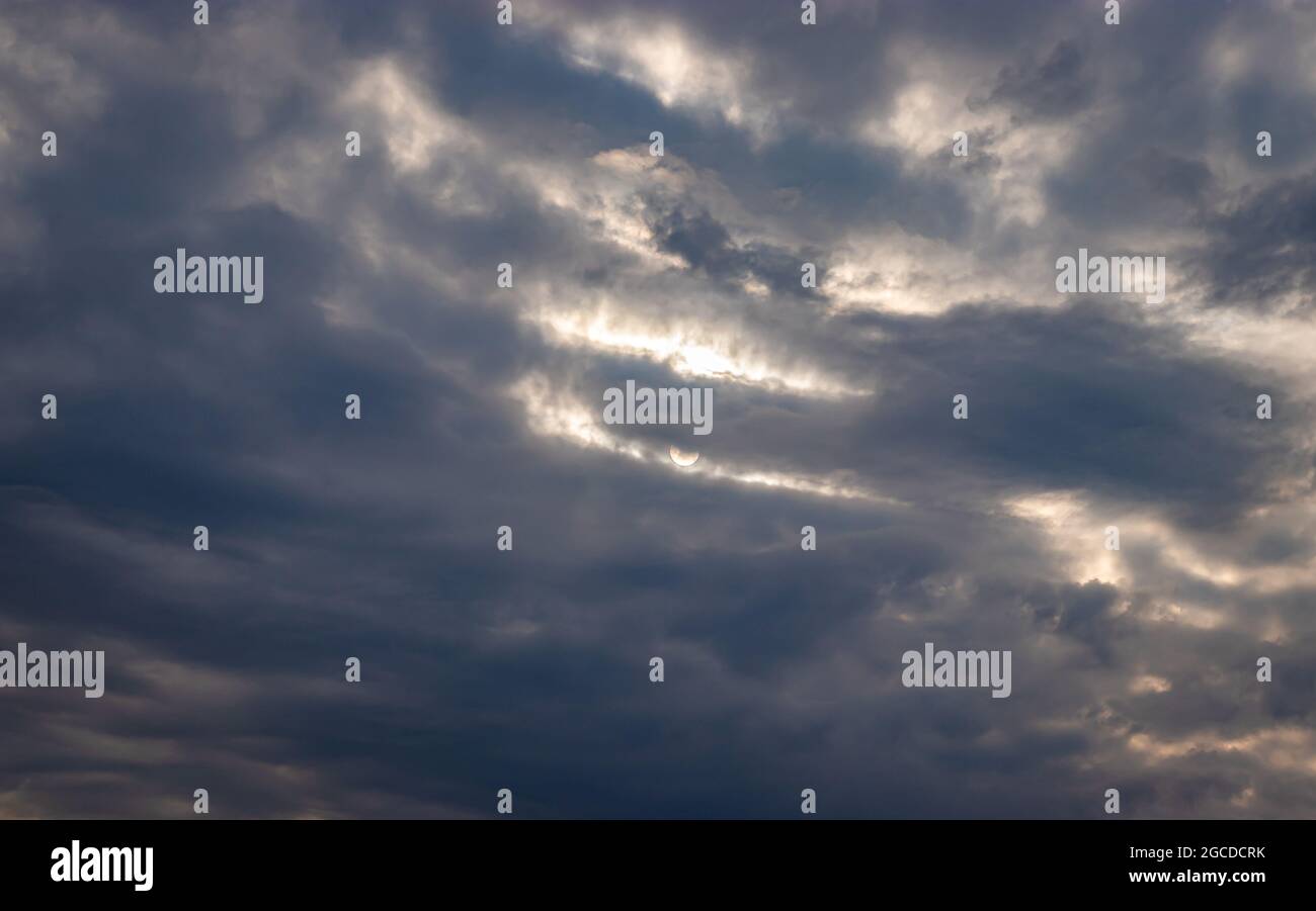 cloudy sky with sun at dusk from low angle Stock Photo - Alamy