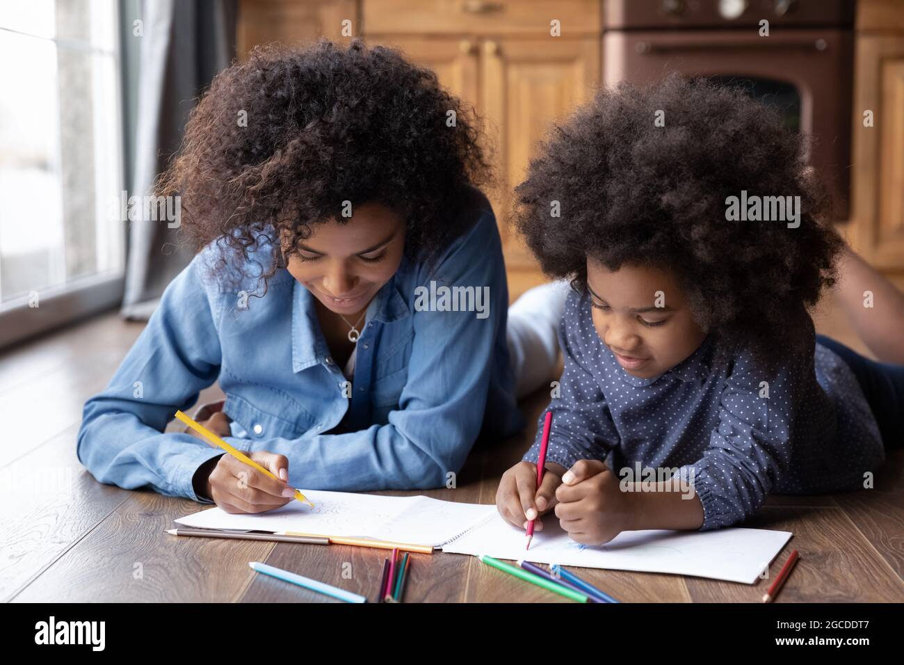 Happy biracial mom and daughter drawing in album Stock Photo - Alamy