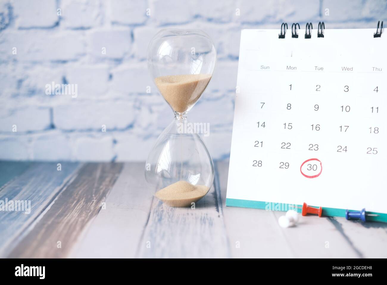 Hourglass on calendar flowing through hi-res stock photography and ...
