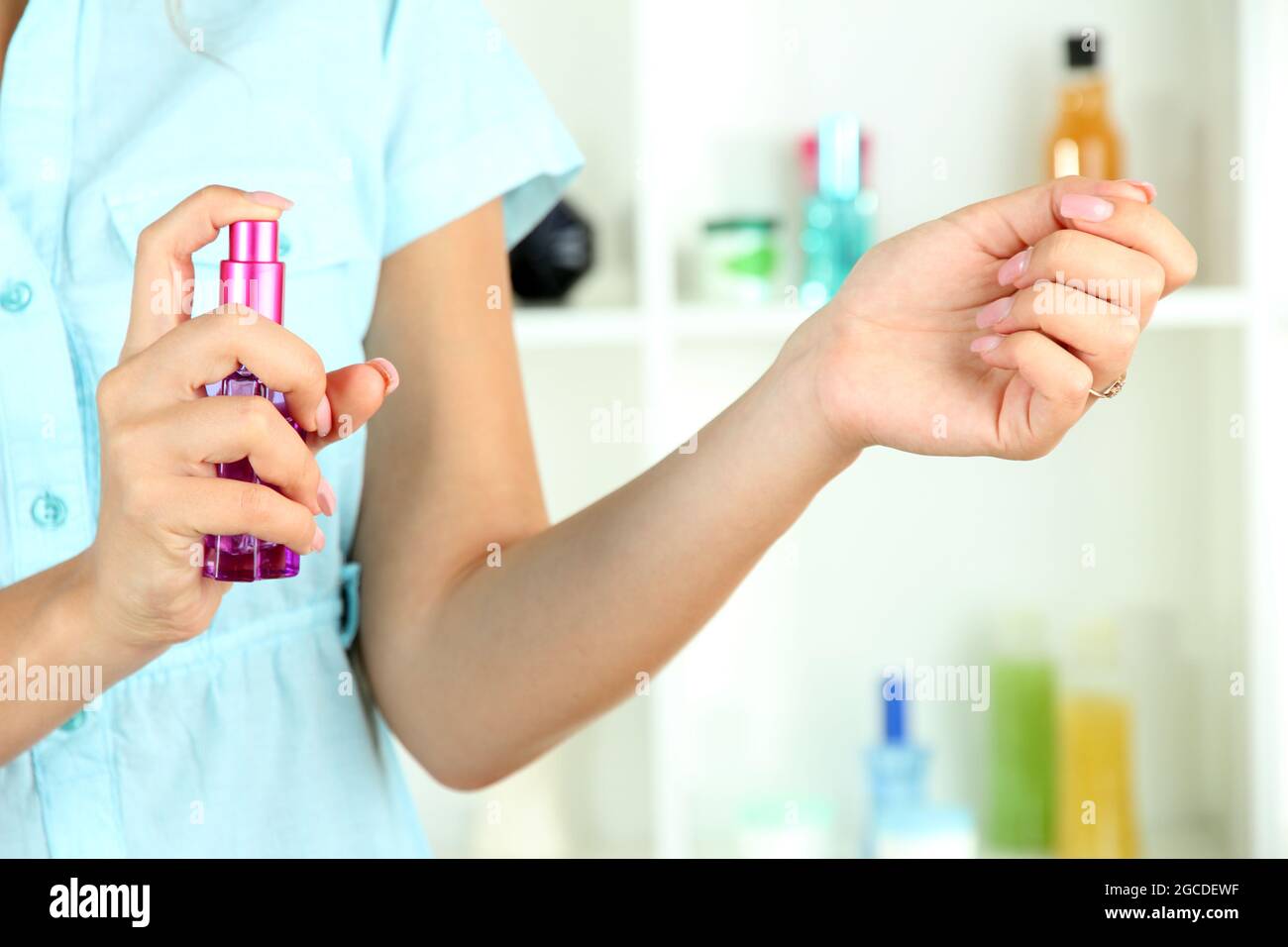 Woman testing perfume on shop windows background Stock Photo - Alamy