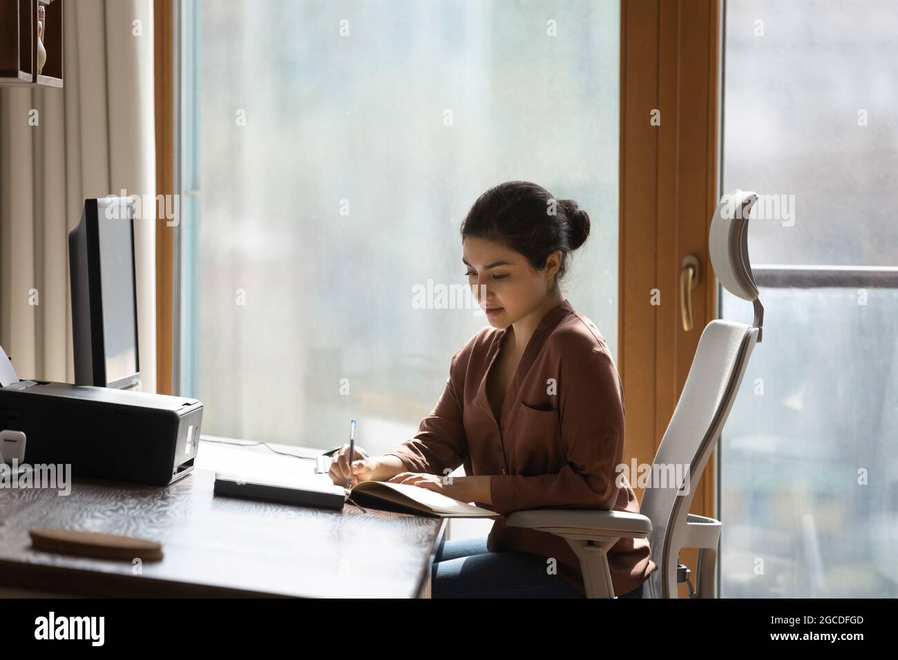 Teen Indian woman write working on computer Stock Photo - Alamy