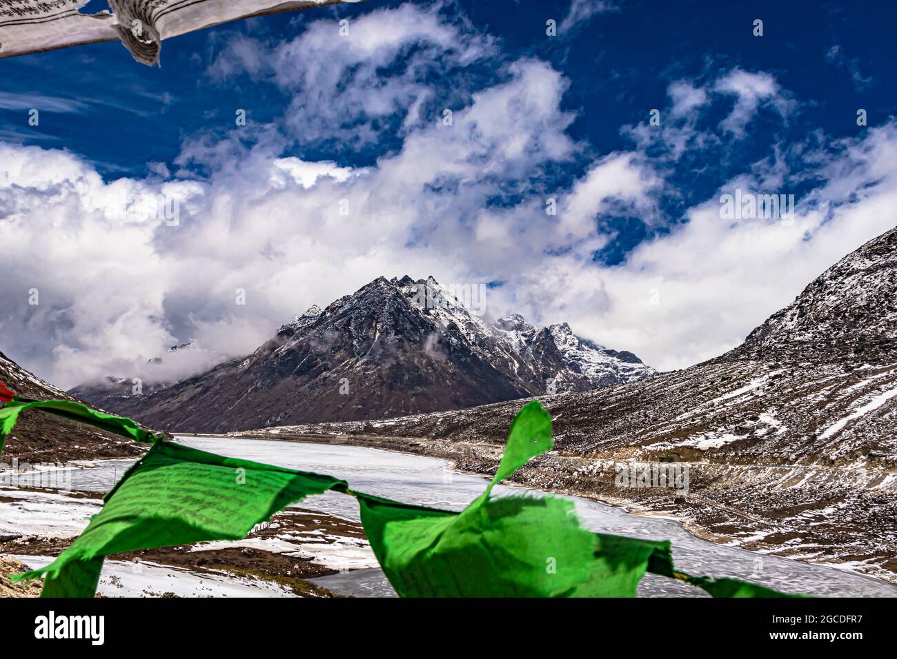 snow cap mountain with dramatic sky through the blurred buddhism flags ...