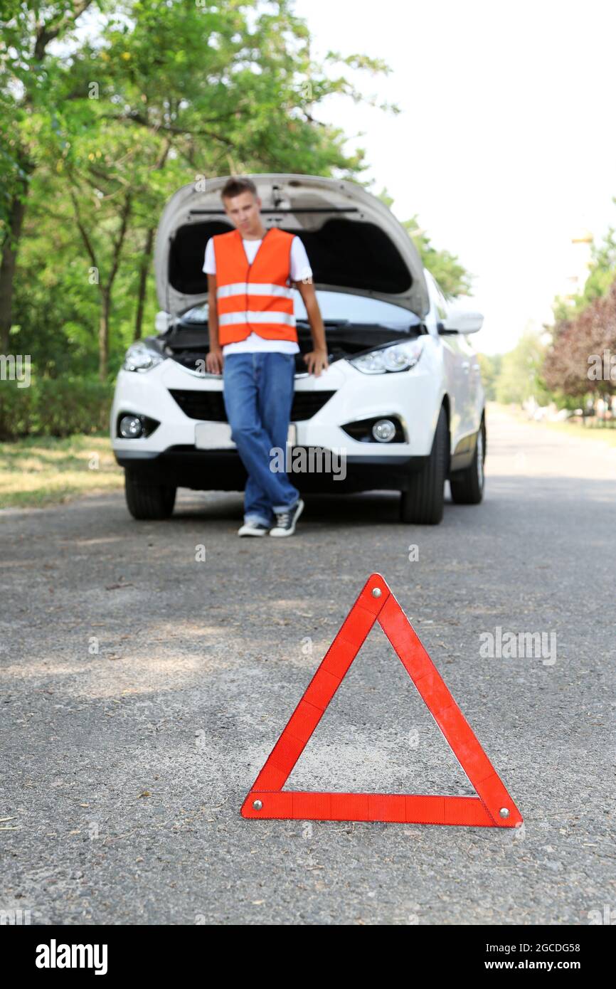 Broken down car with red warning triangle Stock Photo - Alamy