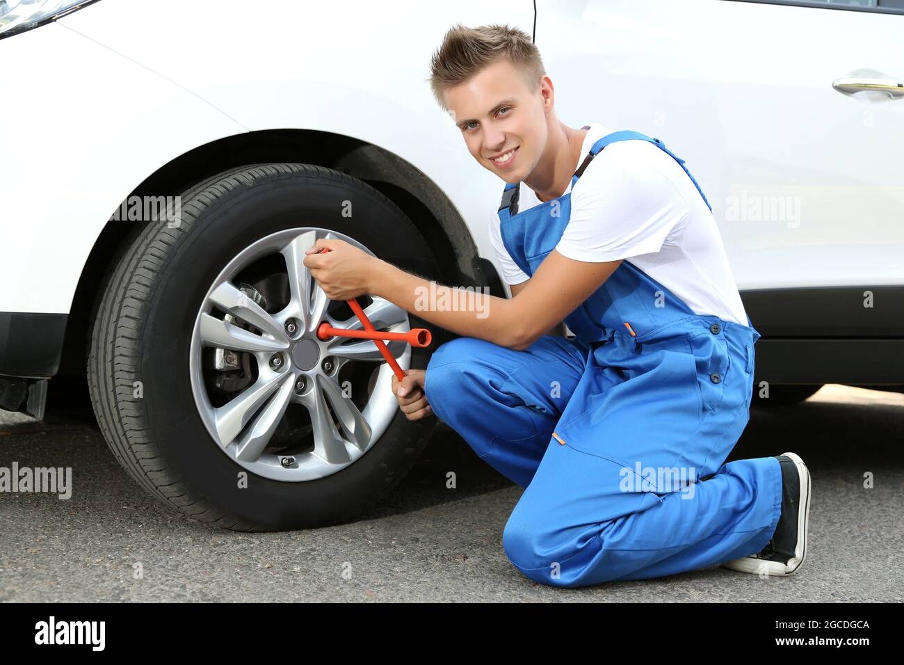 Auto mechanic changing wheel Stock Photo - Alamy