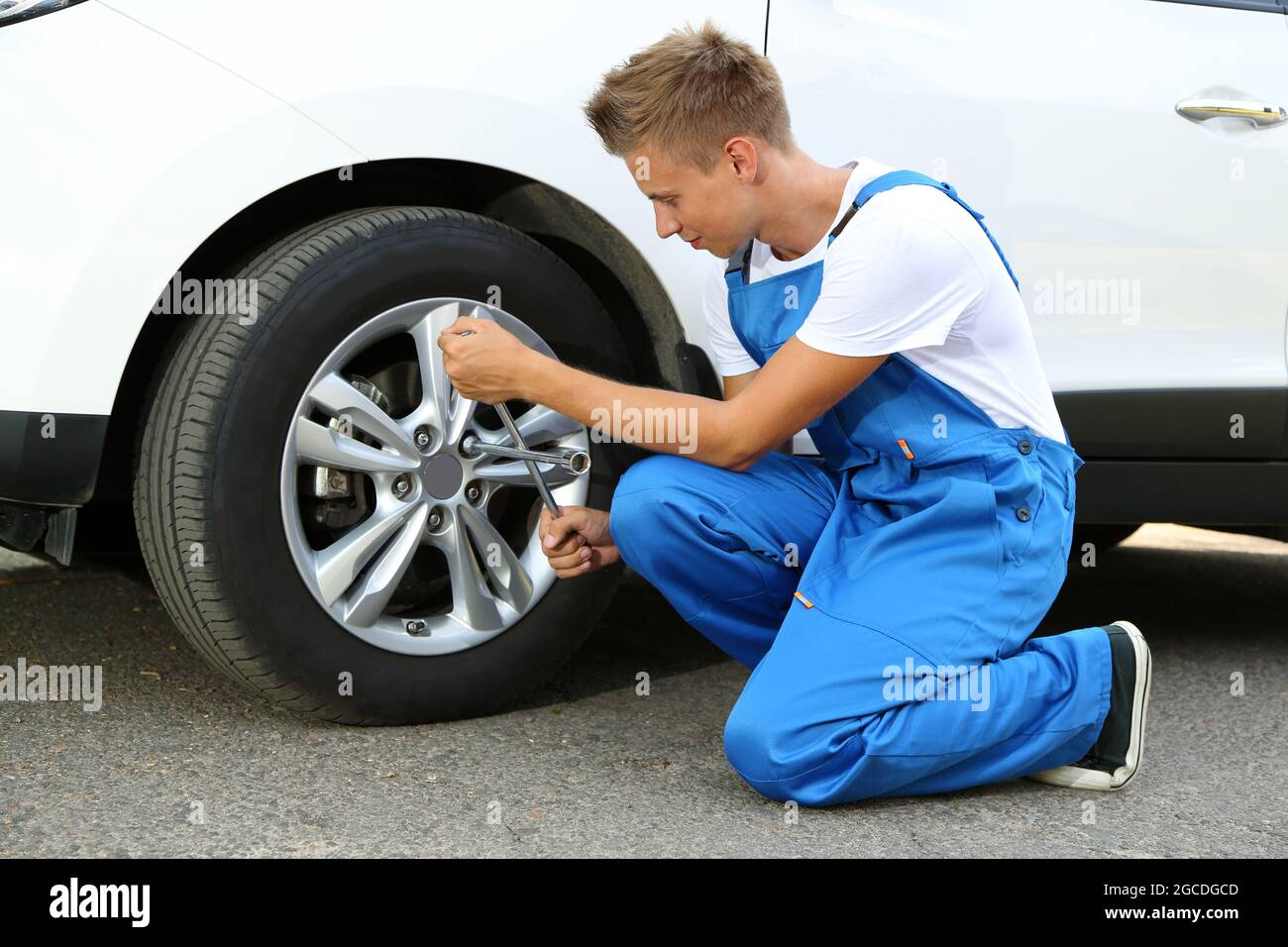 Auto mechanic changing wheel Stock Photo - Alamy