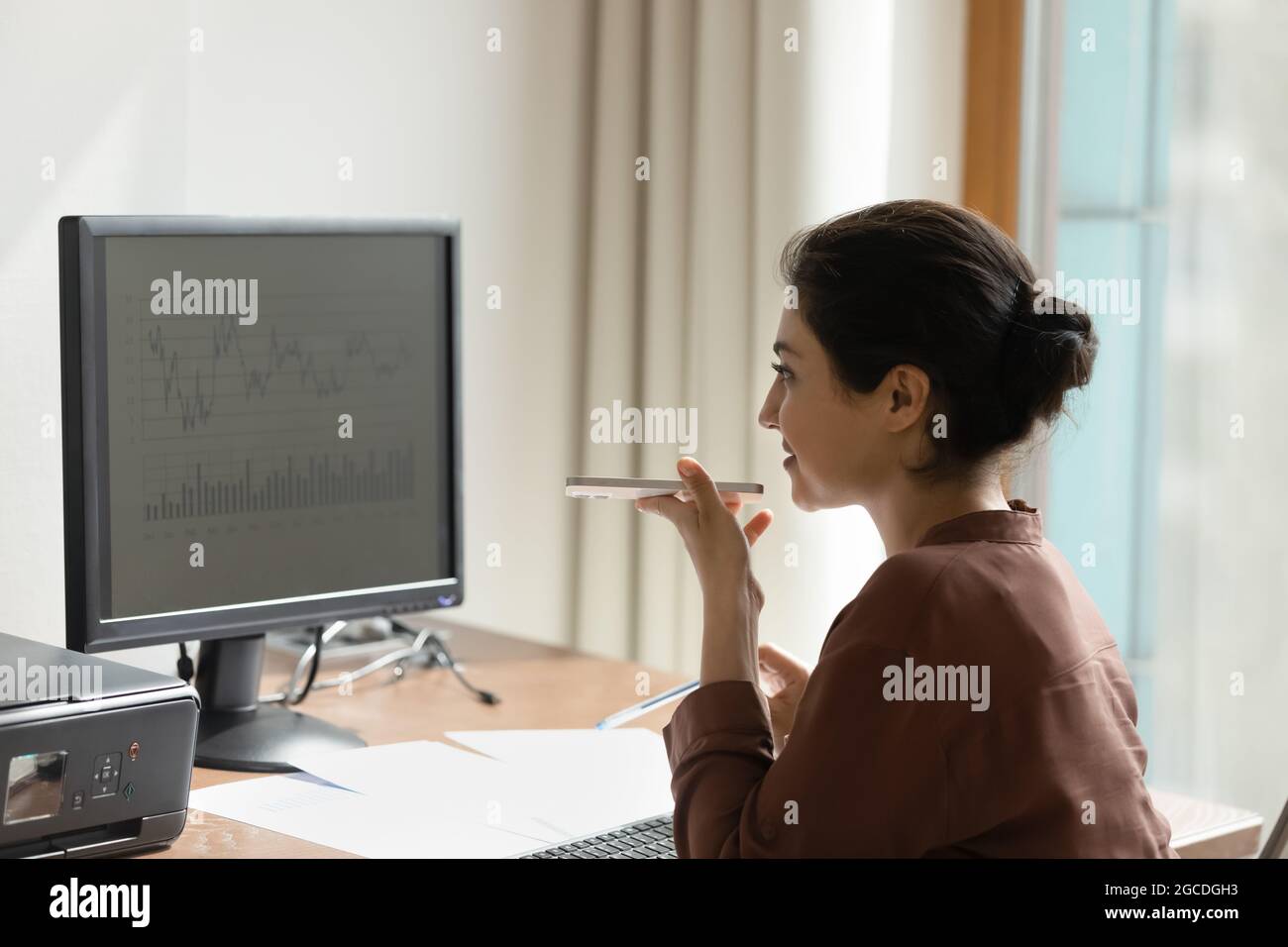 Young Indian woman work on computer talk on cell Stock Photo - Alamy