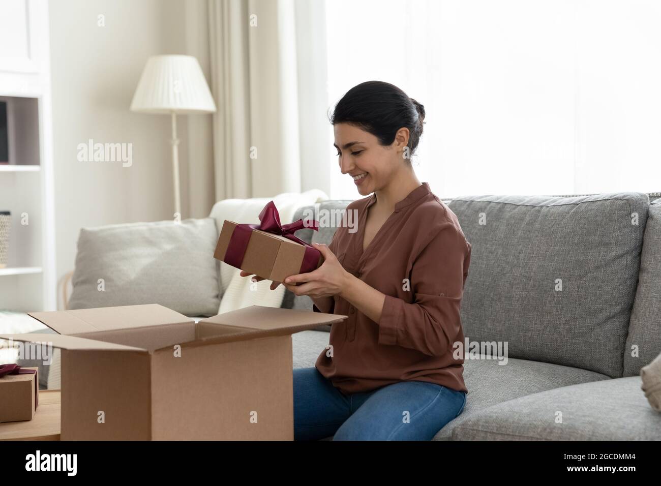 Happy Indian woman unbox parcel with present surprise Stock Photo - Alamy