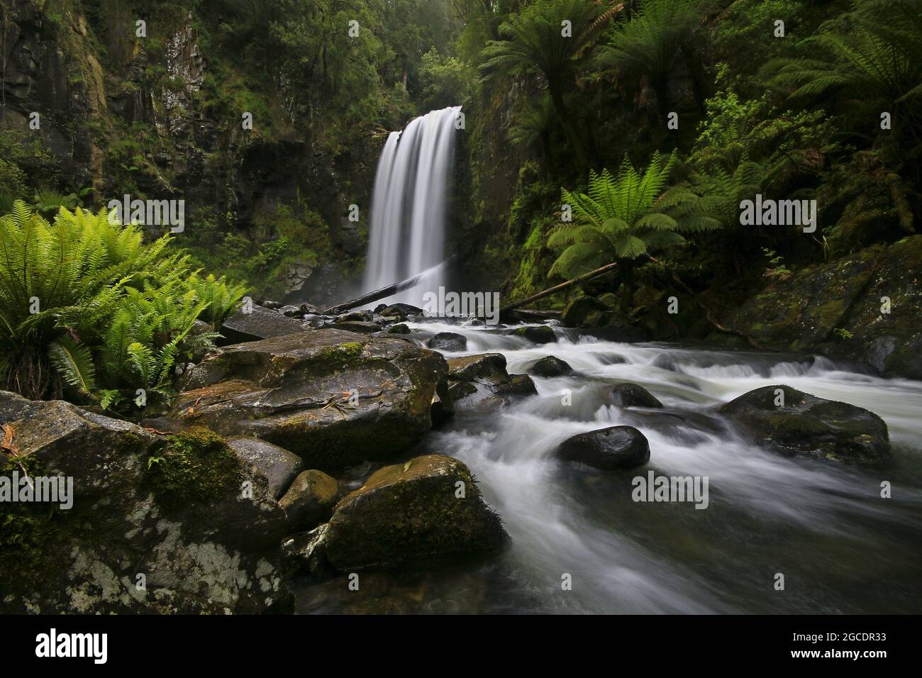 a large waterfall over some water Stock Photo - Alamy