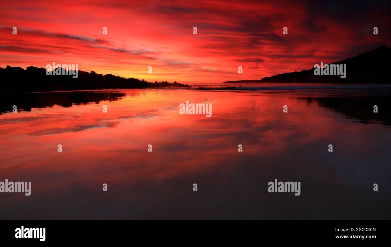 a sunset over a body of water Stock Photo - Alamy