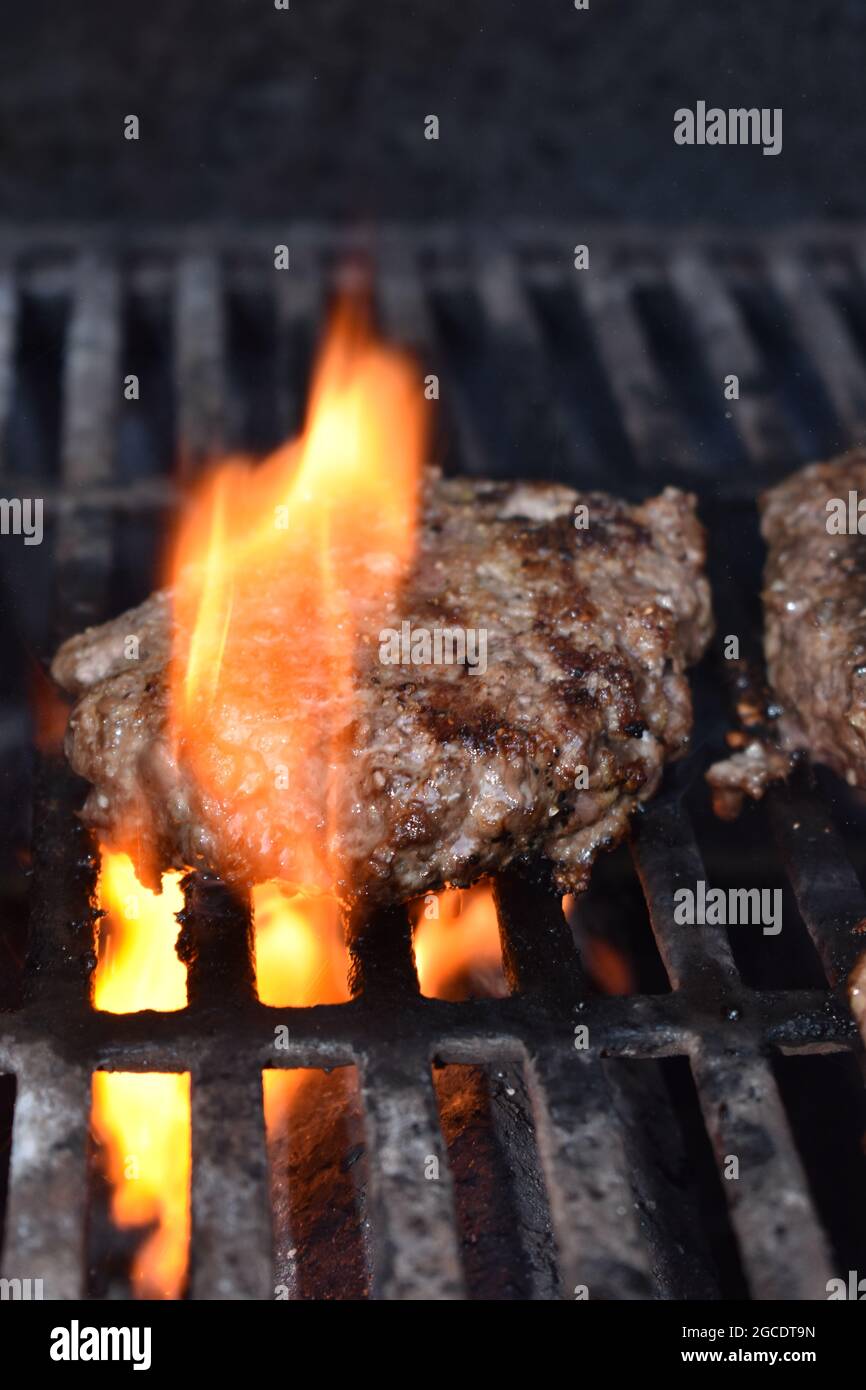 Beef hamburger cooking on a gas grill Stock Photo - Alamy
