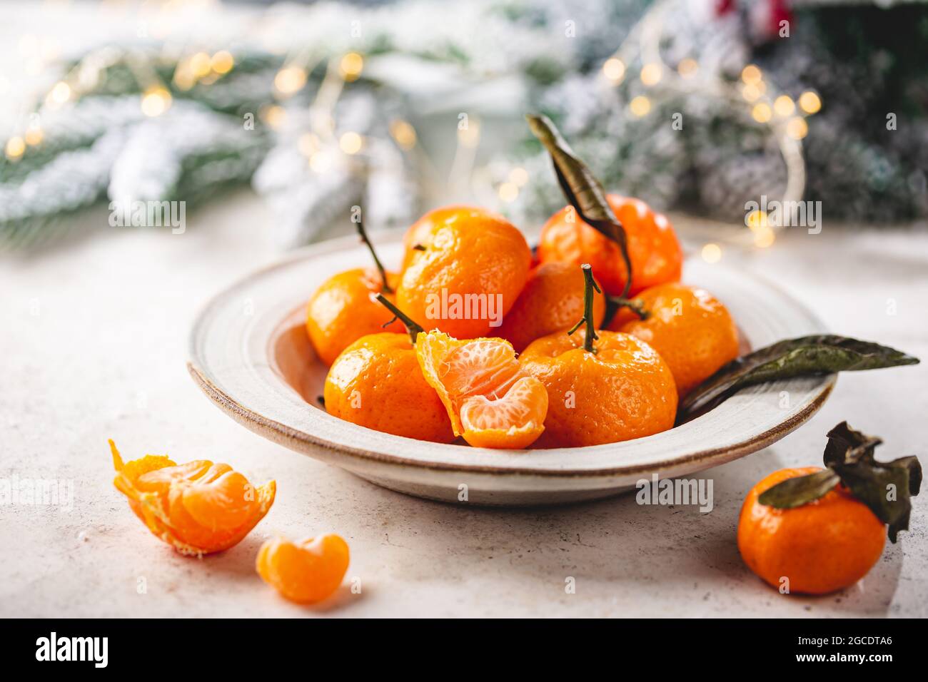 Fresh mandarin fruit or tangerines with leaves in a bowl on white ...
