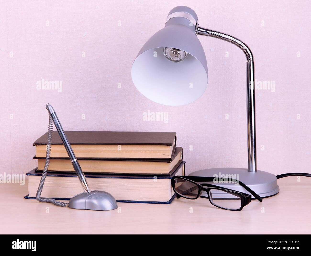 Table lamp with books on desk in room Stock Photo - Alamy