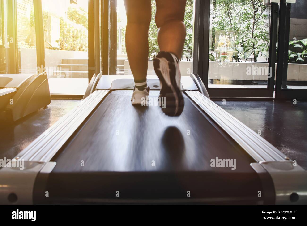 Close up shoes woman's running on treadmill. Woman with muscular legs ...