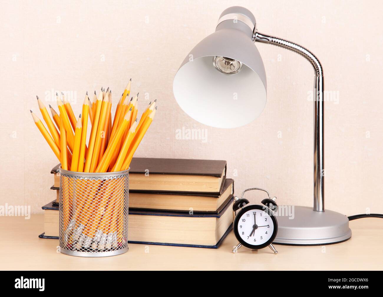 Table lamp with books on desk in room Stock Photo - Alamy