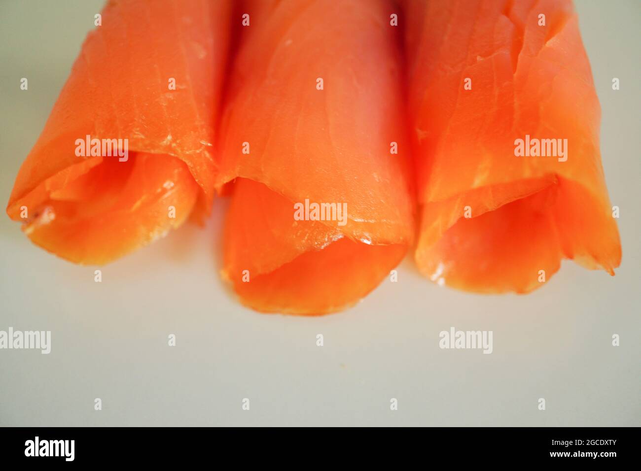 smoked salmon roles on white plate - smoked fish roles on white ...