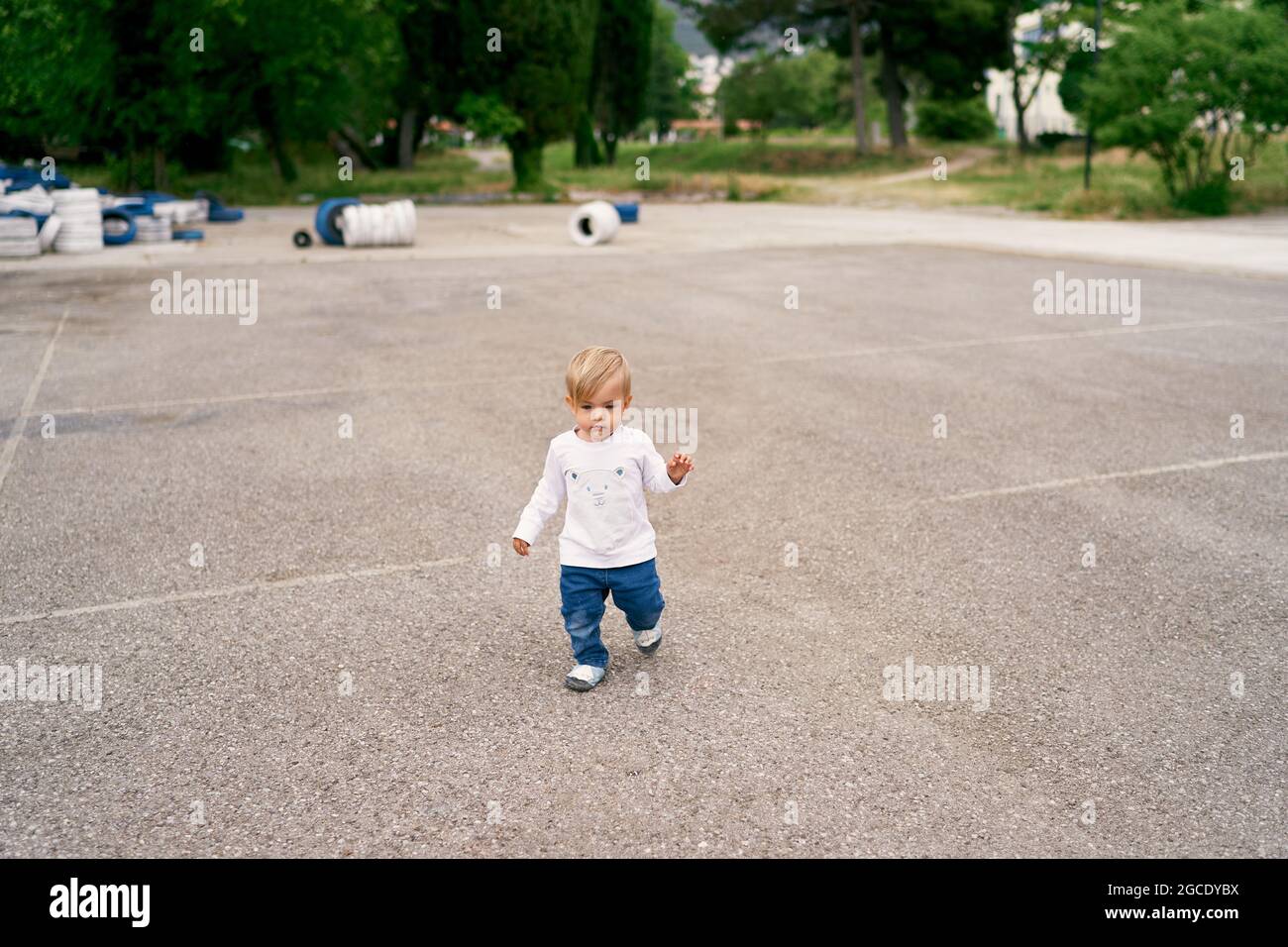 Smiling child walk on a concrete playground Stock Photo - Alamy