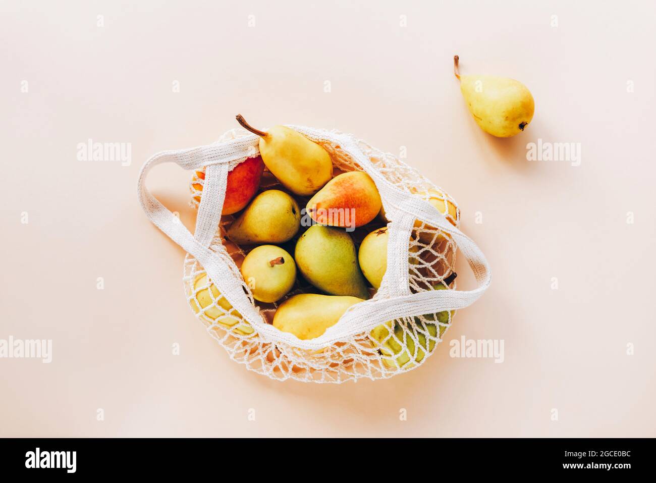 Fresh ripe pears in a string bag on beige background. Zero waste, no ...
